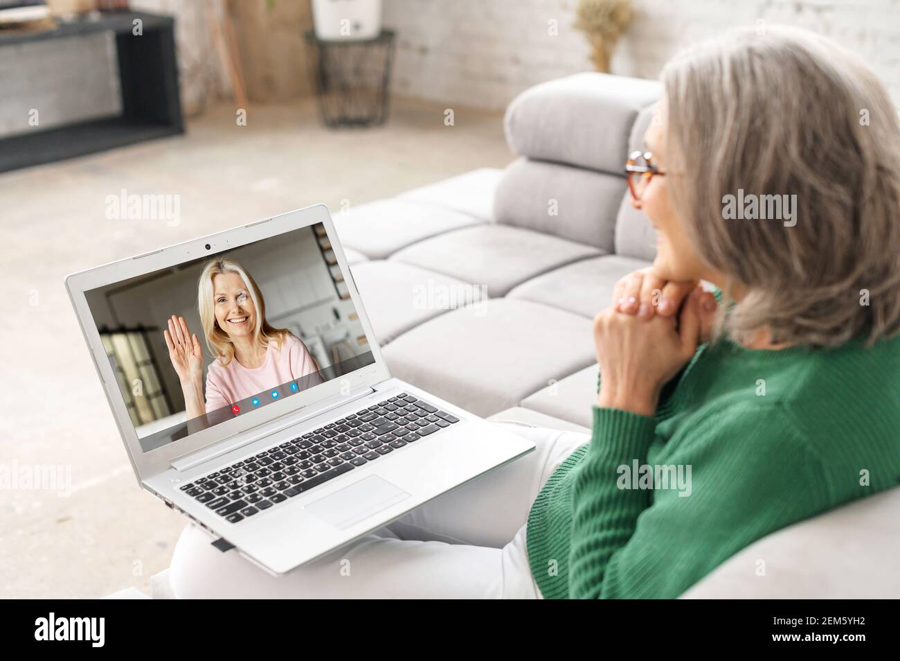 Back view on the laptop screen with a video call participant on it, two ...