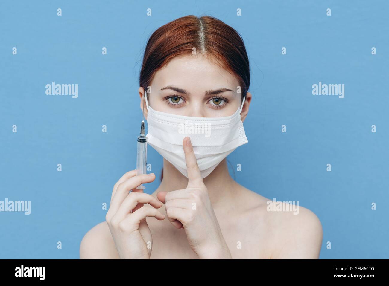 emotional woman with syringe in hand and medical mask injection vaccine ...