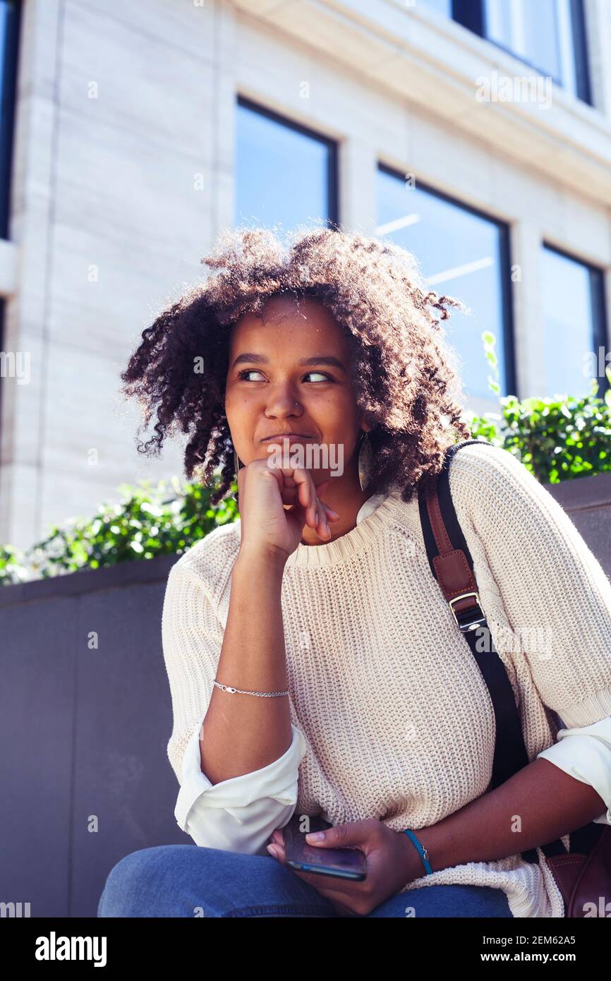 young pretty african girl posing cheerful on city background, lifestyle ...