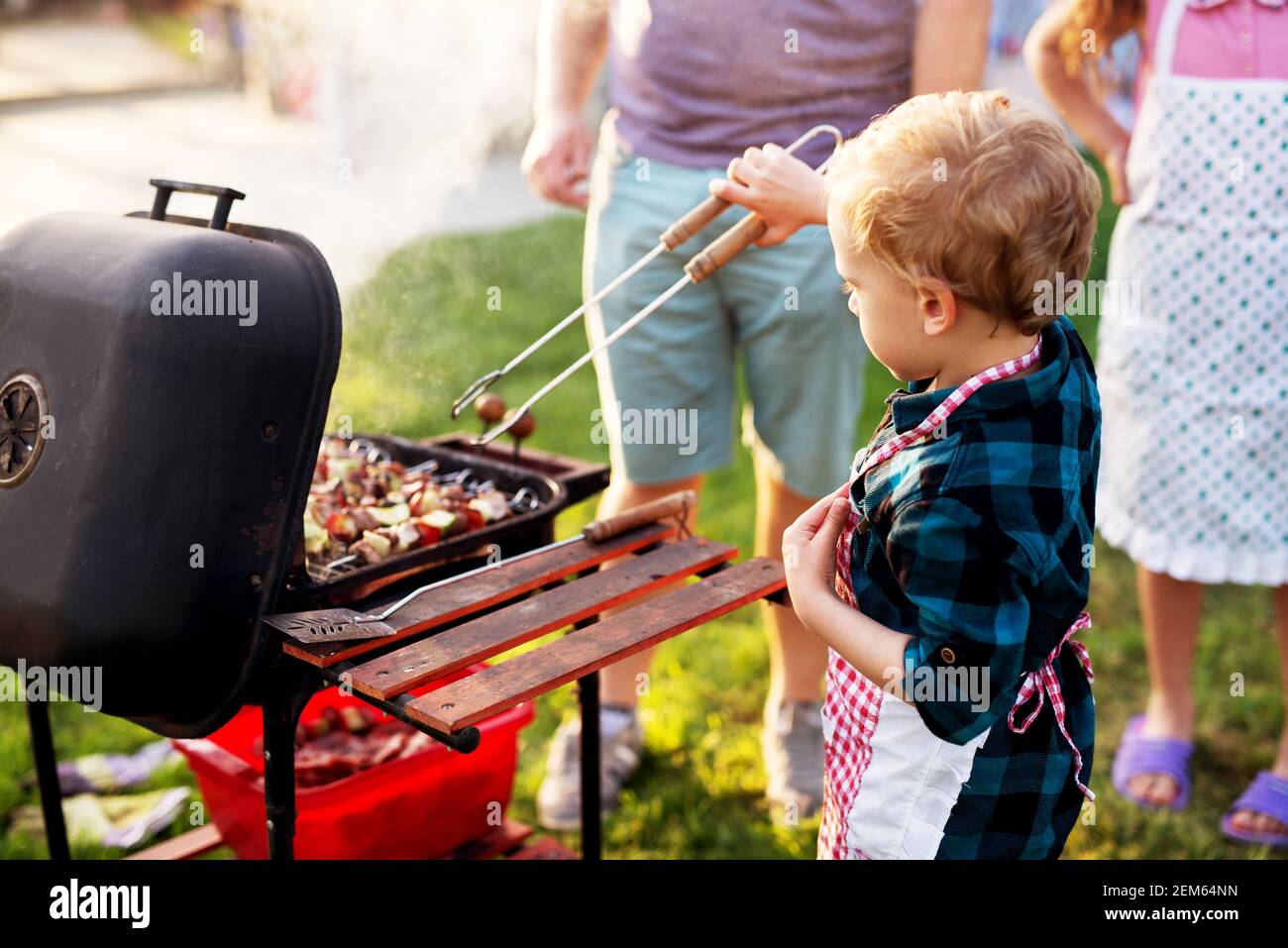 Little adorable toddler boy is using cooking clip to help his parents ...