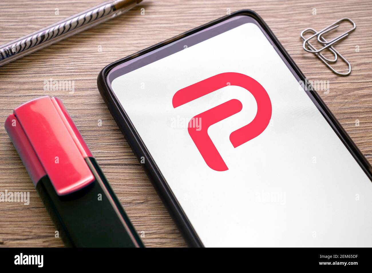 Smartphone with red parler logo on wooden table. Phone concept ...