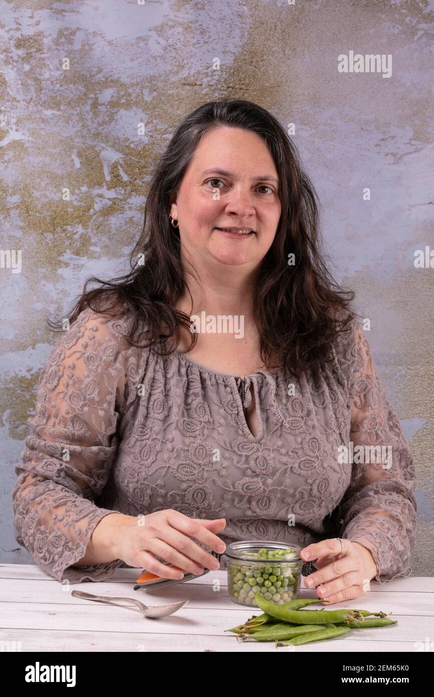 Woman with a jar of raw peas on a textured background Stock Photo - Alamy