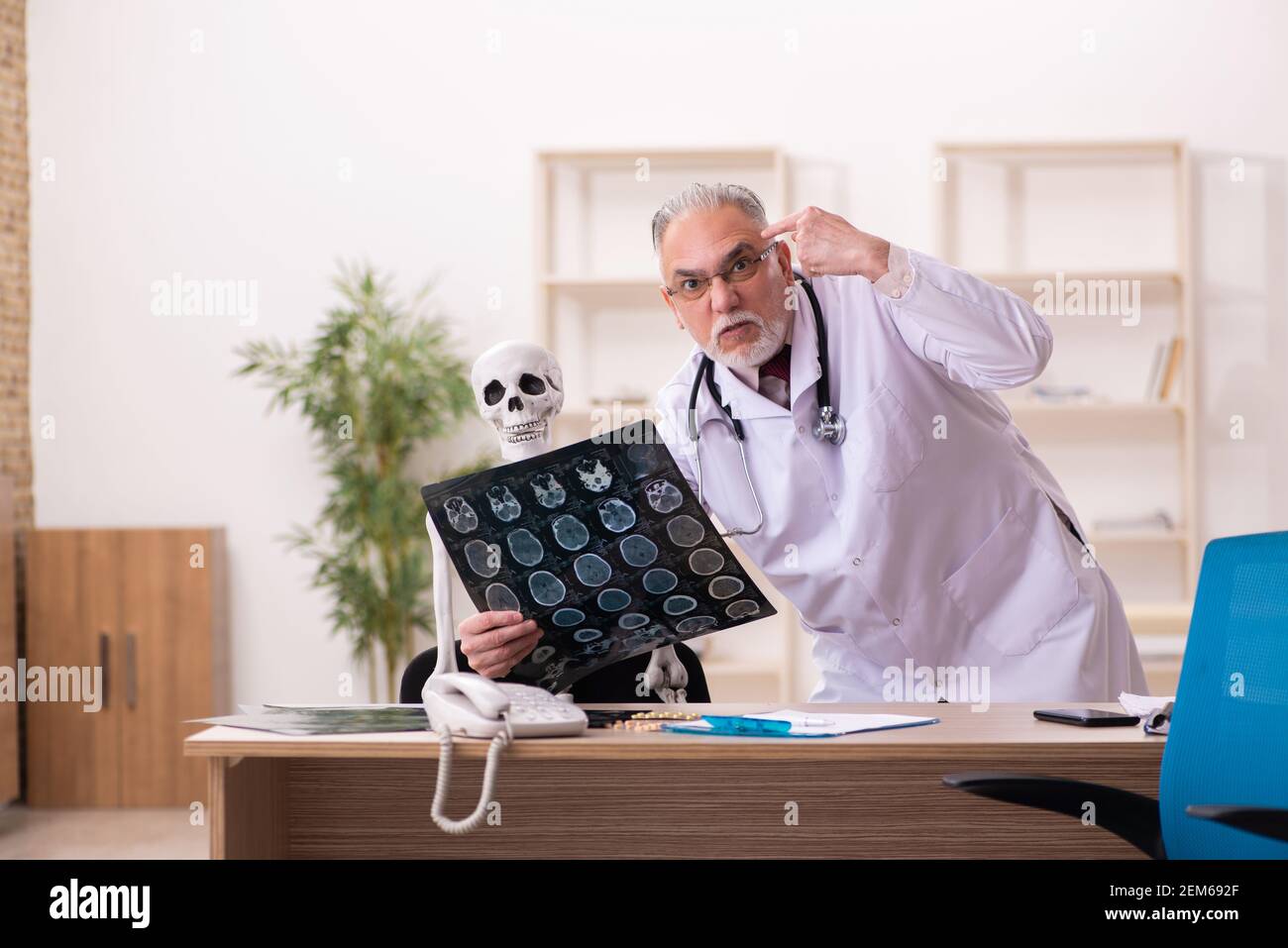 Skeleton patient visiting old male doctor radiologist Stock Photo - Alamy