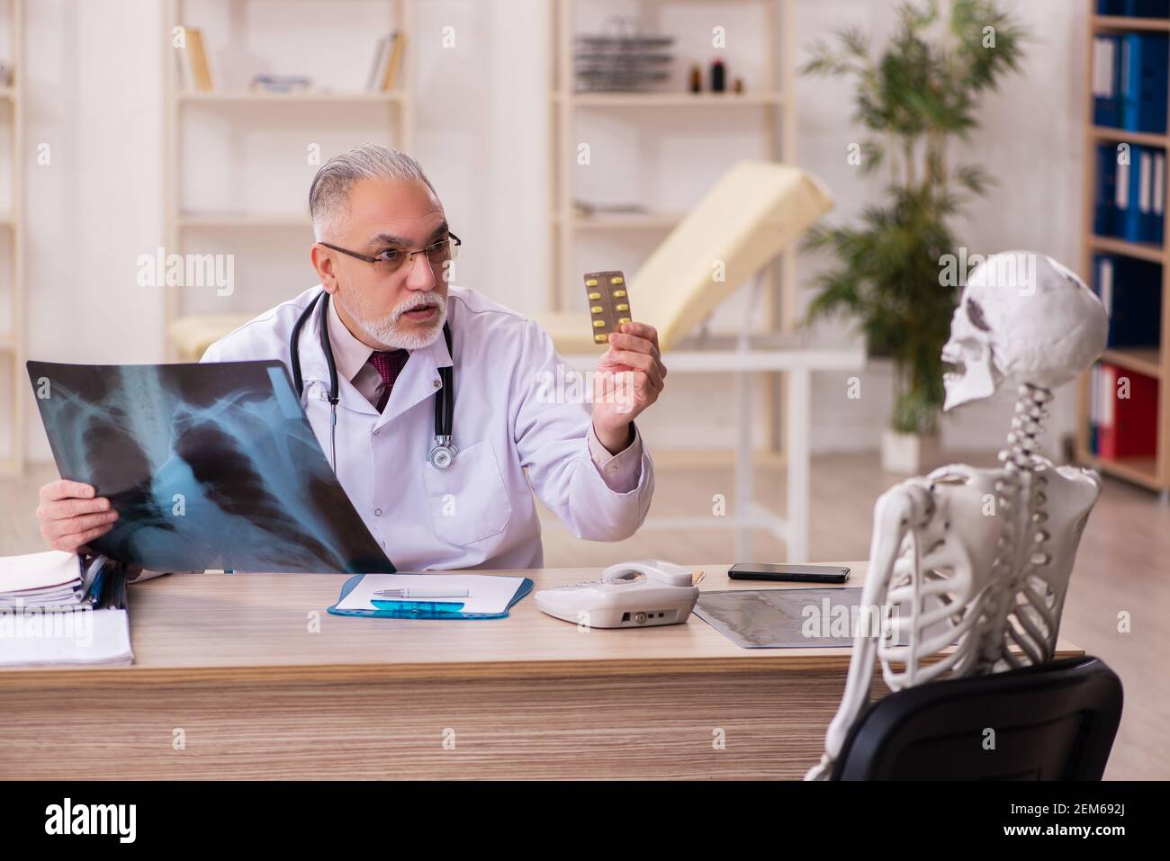 Skeleton patient visiting old male doctor radiologist Stock Photo - Alamy