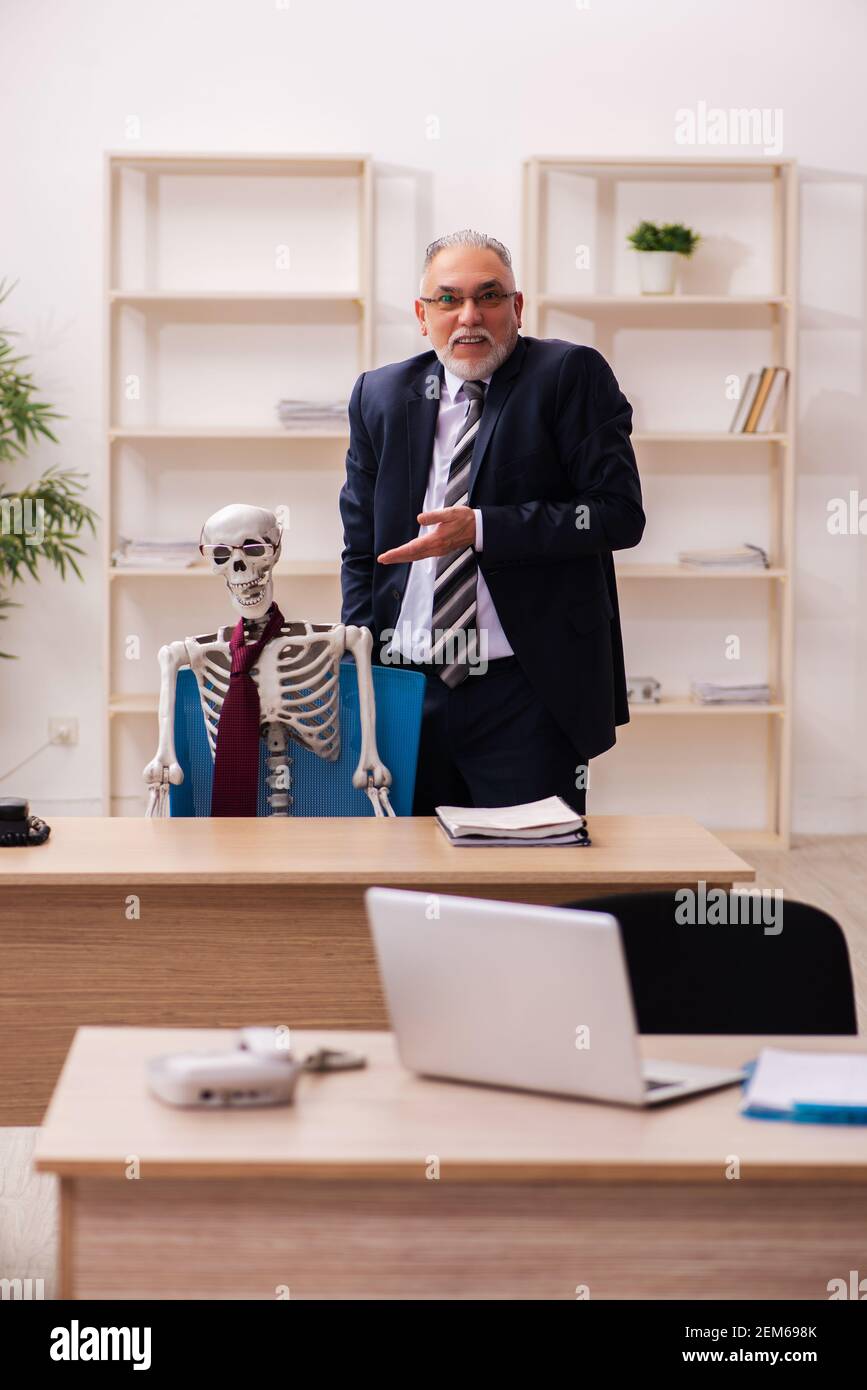 Dead employee working in the office in funny concept Stock Photo - Alamy