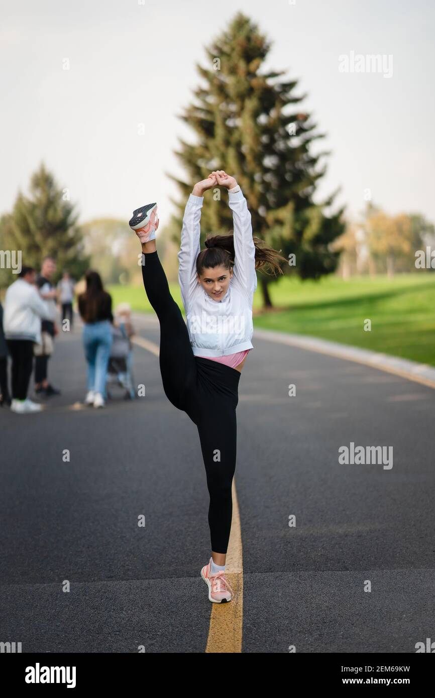 Woman in sport outfit on the road doing doing splits standing Stock ...
