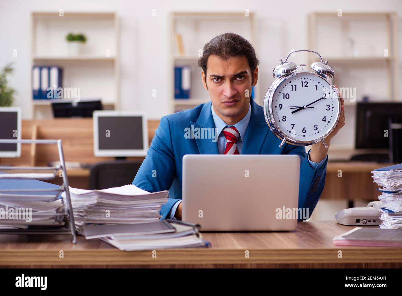 Young employee in time management concept Stock Photo - Alamy