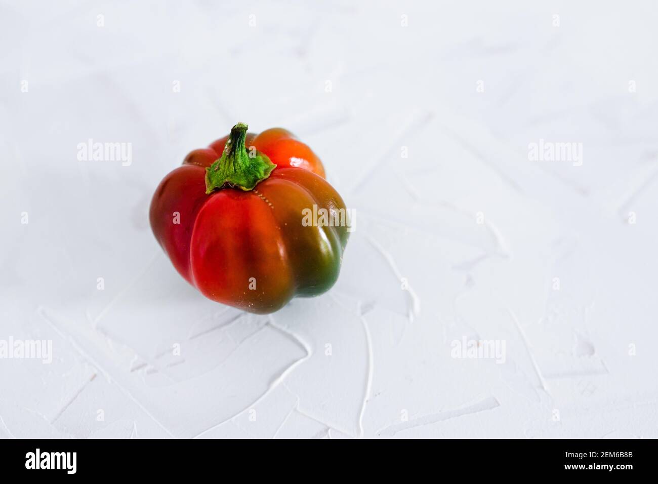 small bell pepper ripening from green to red isolated on white ...