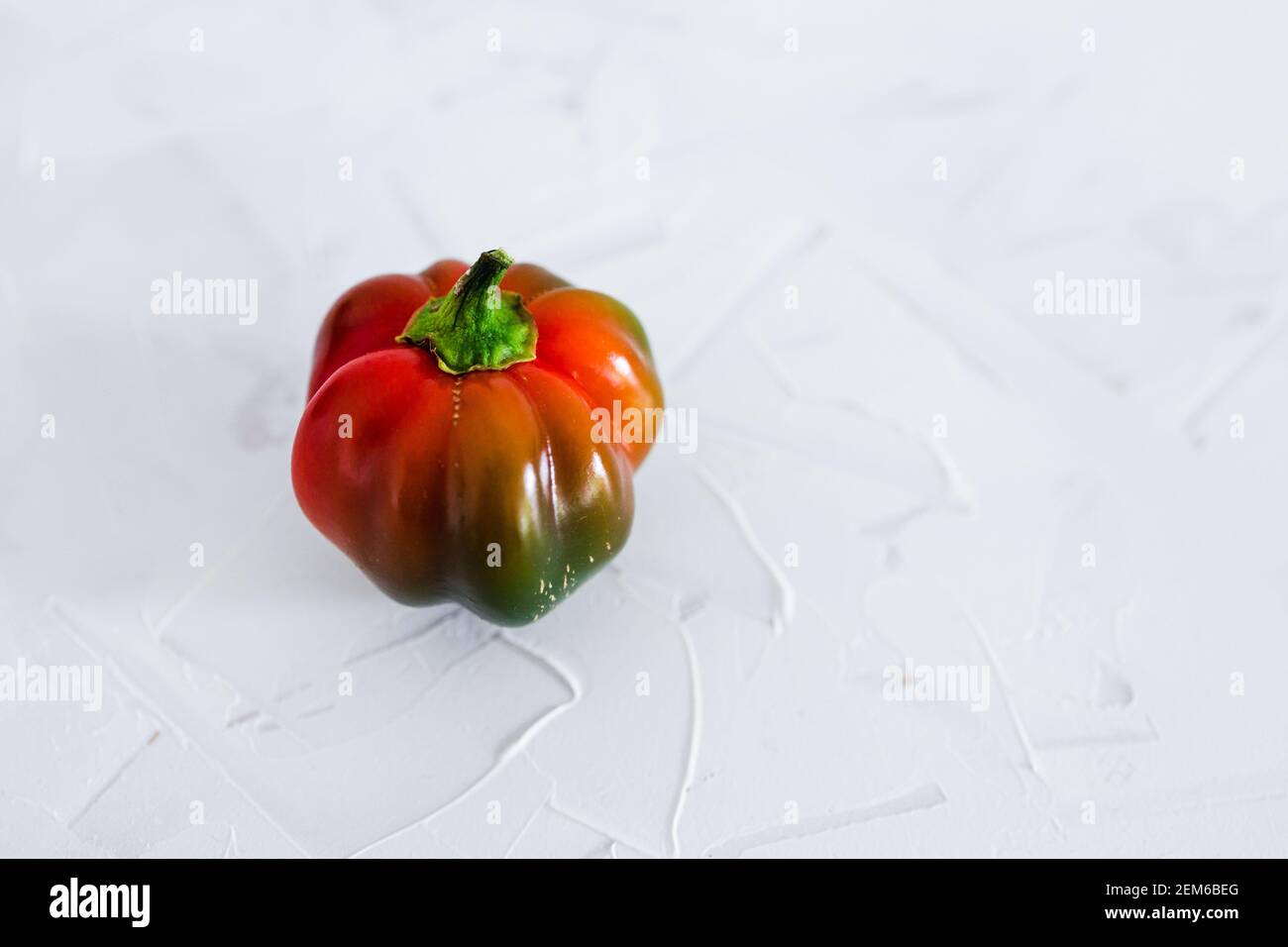 small bell pepper ripening from green to red isolated on white ...