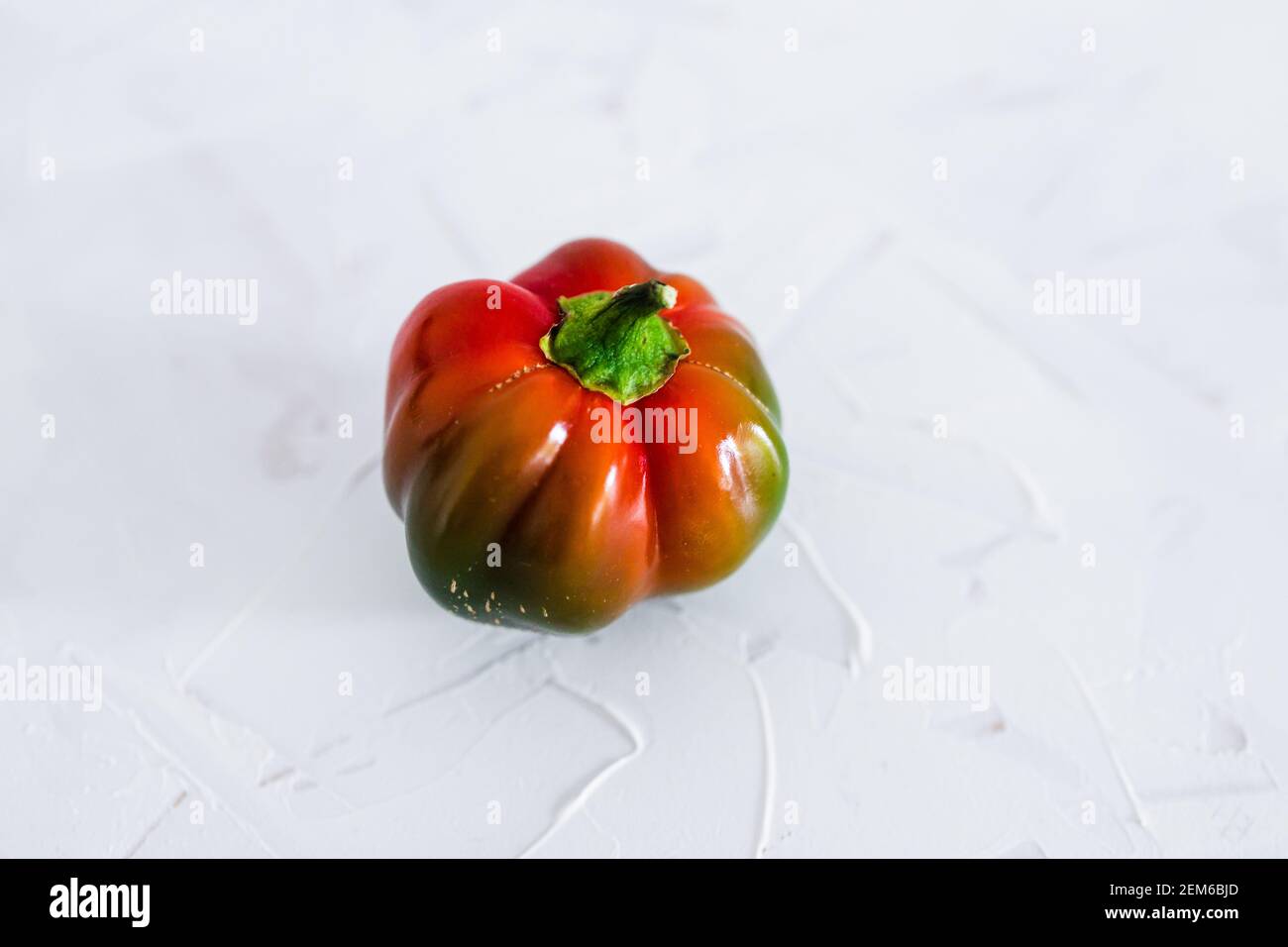 small bell pepper ripening from green to red isolated on white ...