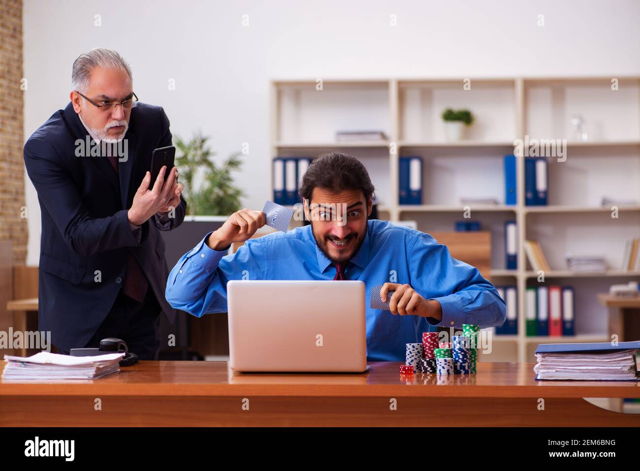 Two male employees in gambling concept in the office Stock Photo - Alamy