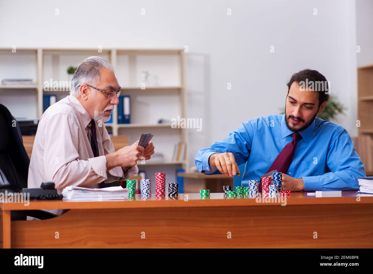 Two employees playing cards at workplace Stock Photo - Alamy