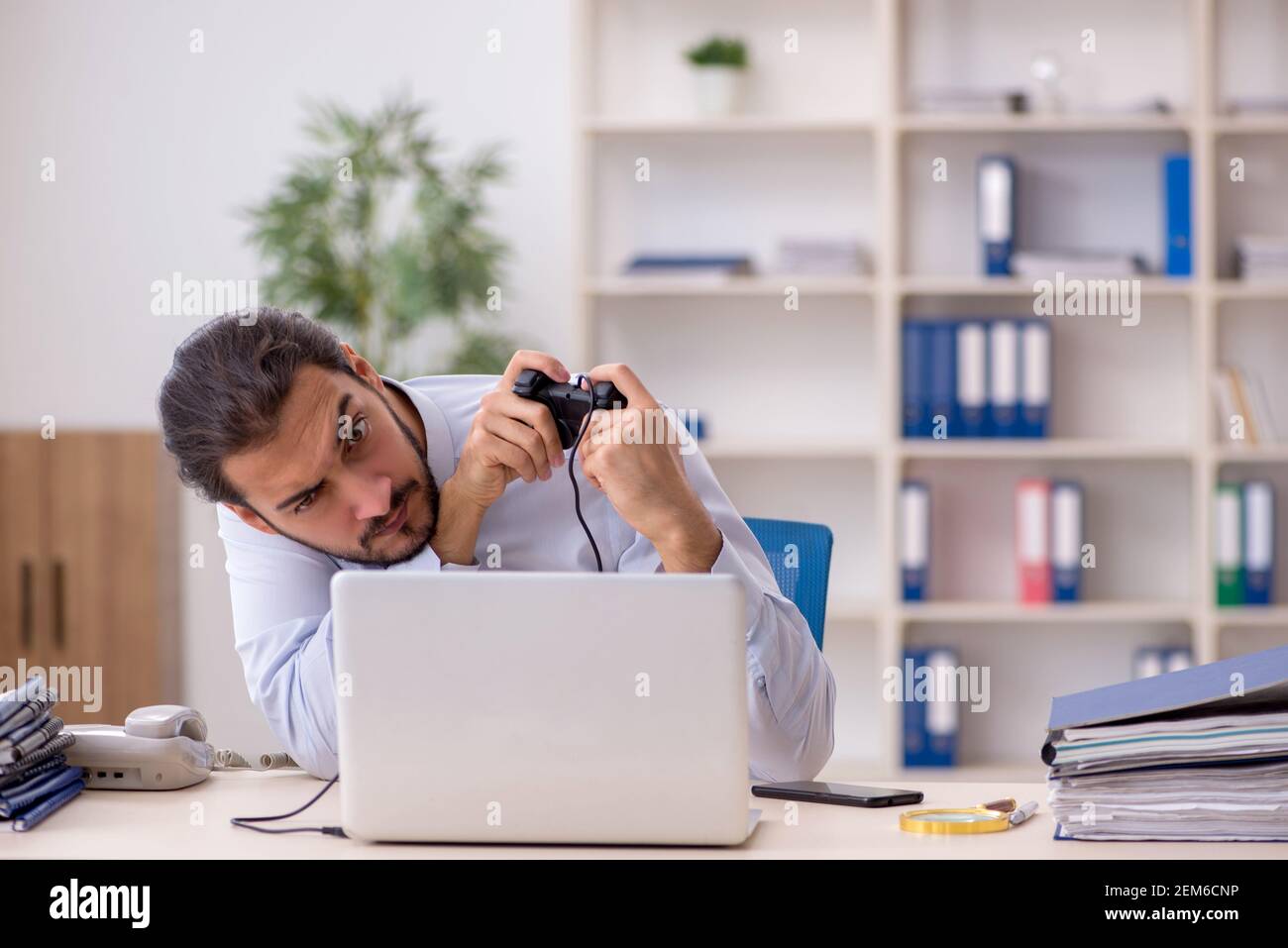 Young employee playing joystick games during his break Stock Photo - Alamy