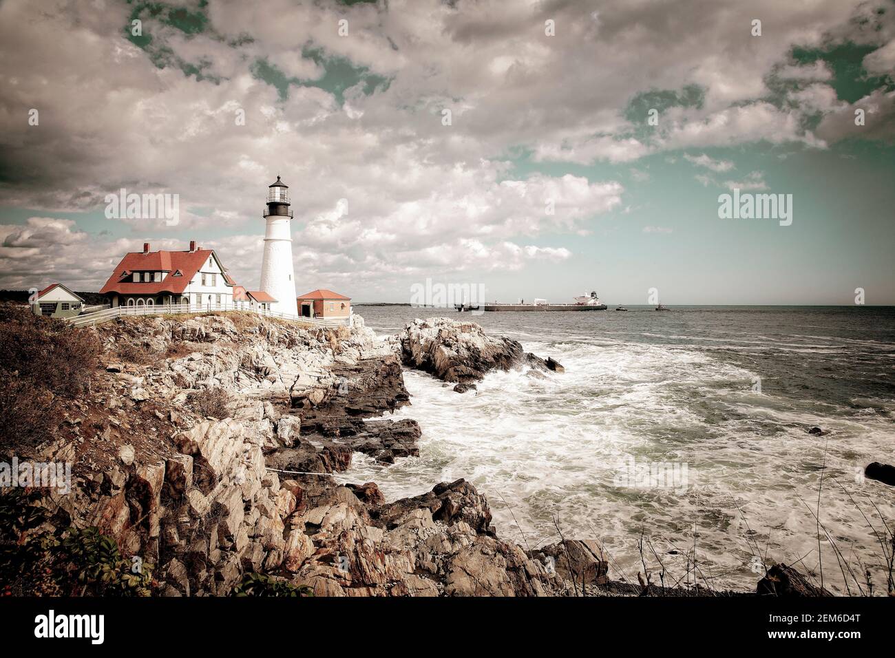 Waves crash against the rocky shore around the Portland Head Lighthouse ...