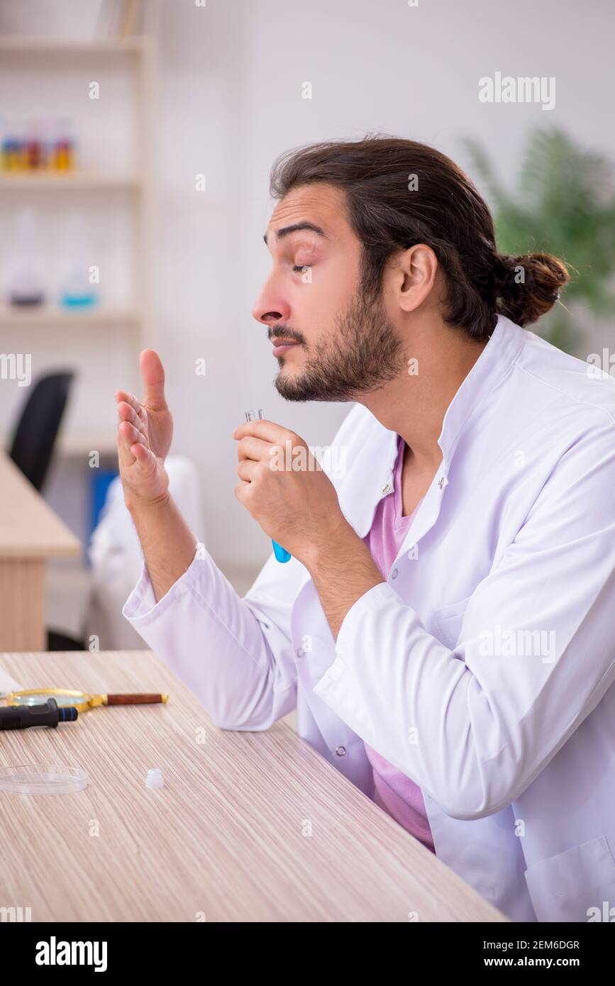 Young chemist sitting at the desk in the classroom Stock Photo - Alamy