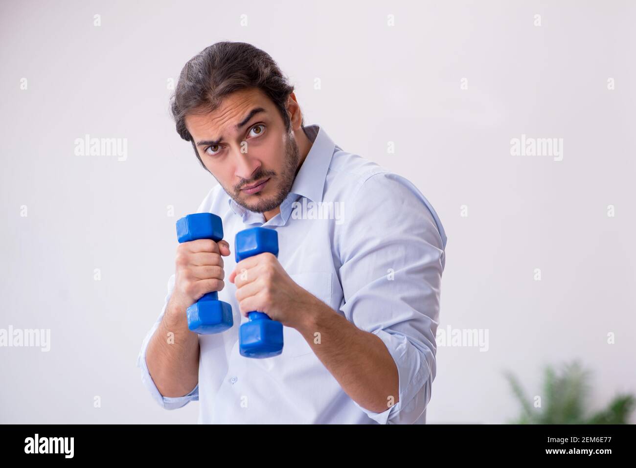 Young employee doing sport exercises during break Stock Photo - Alamy