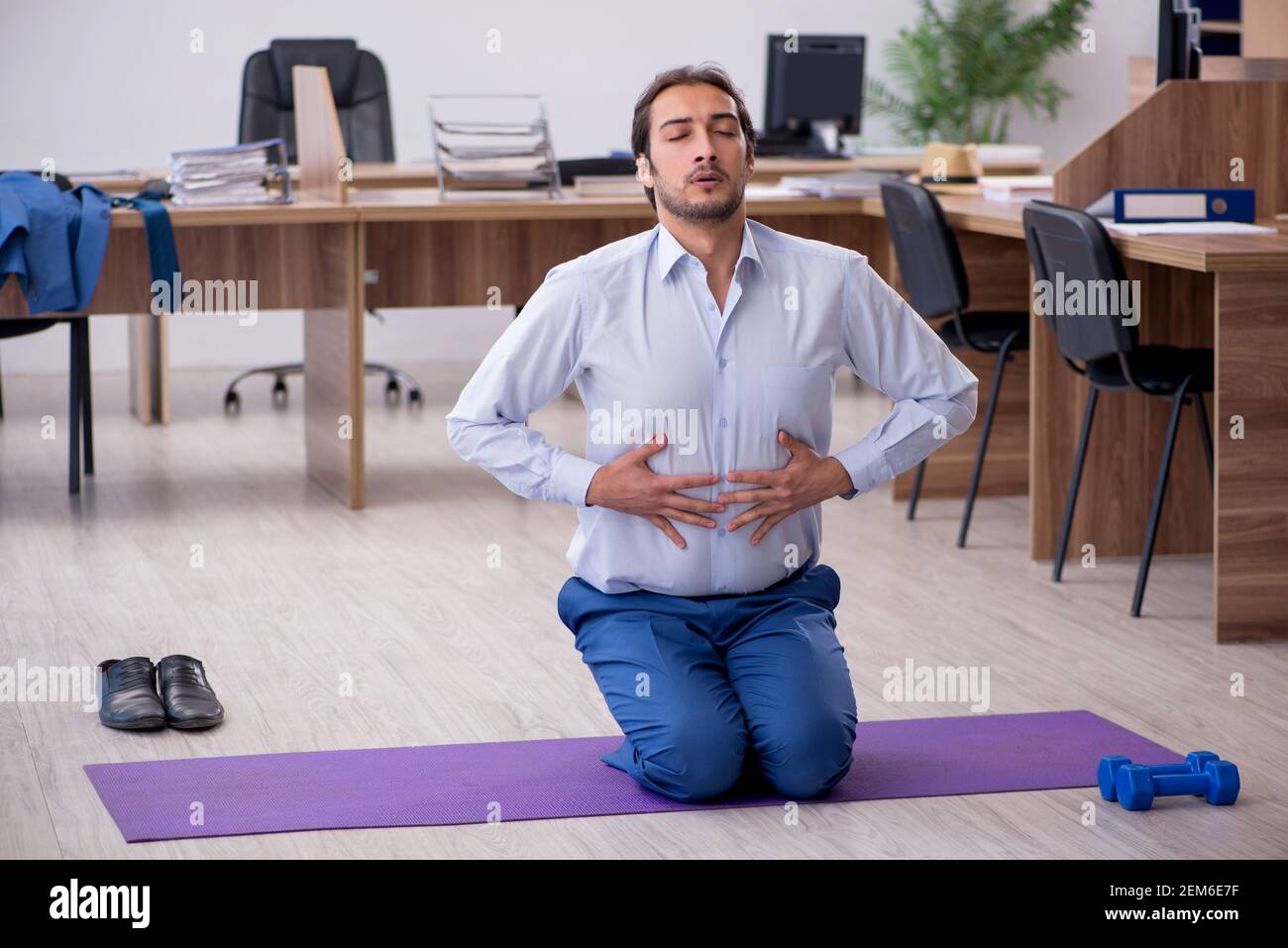 Young employee doing sport exercises during break Stock Photo - Alamy