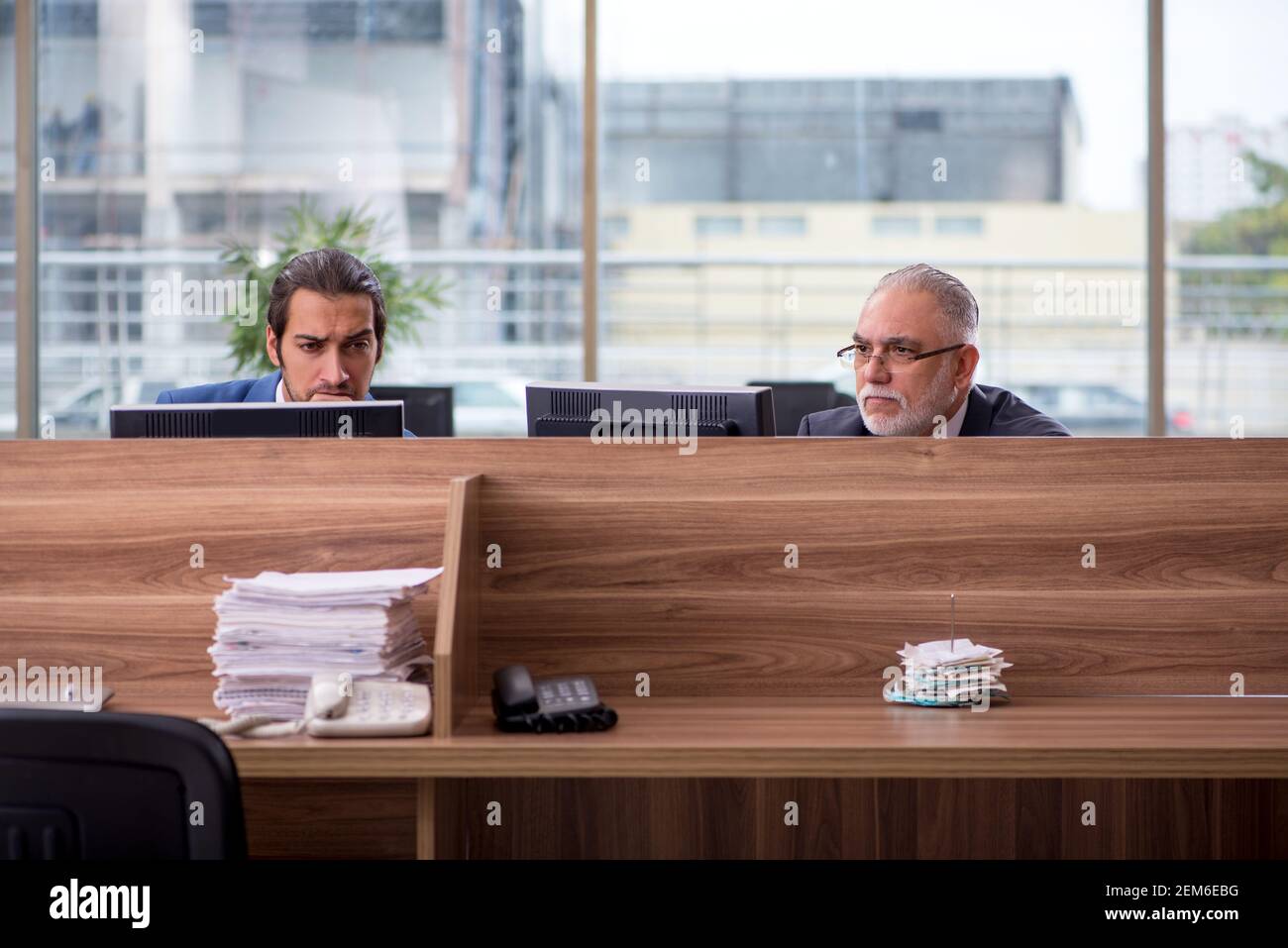 Two businessmen employees sitting in the office Stock Photo - Alamy