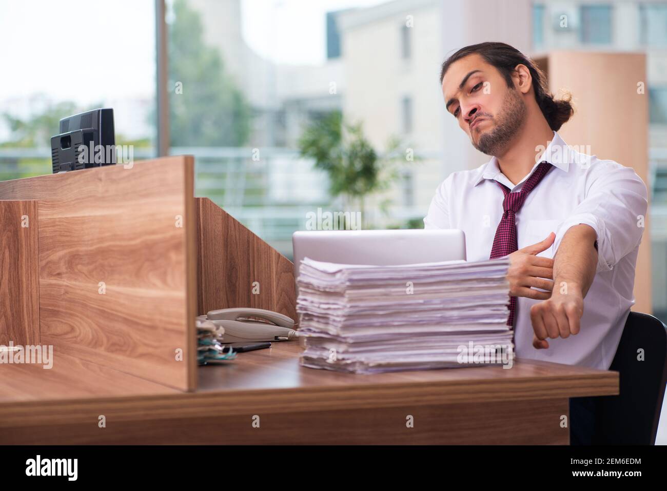 Young employee and too many work in the office Stock Photo - Alamy