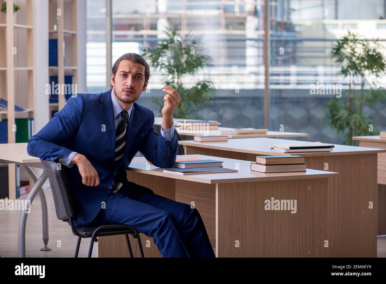 Young teacher in suit in the classroom Stock Photo - Alamy