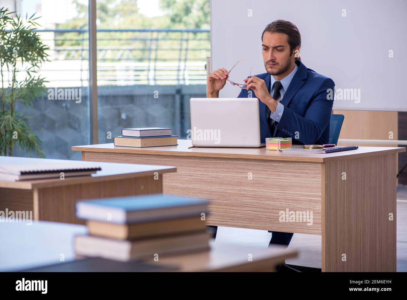 Young teacher in suit in the classroom Stock Photo - Alamy