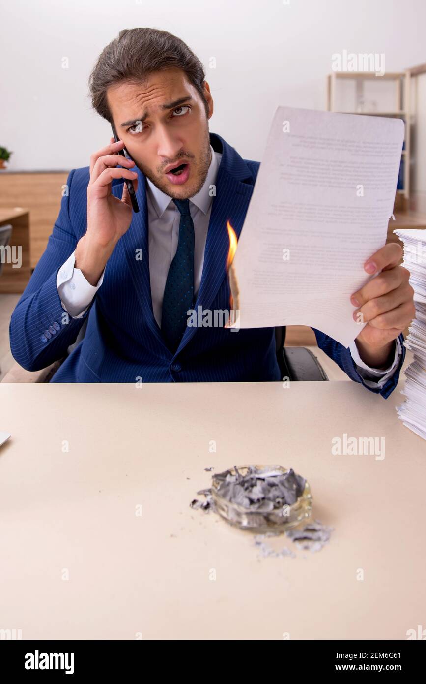 Young man employee burning papers in the office Stock Photo - Alamy