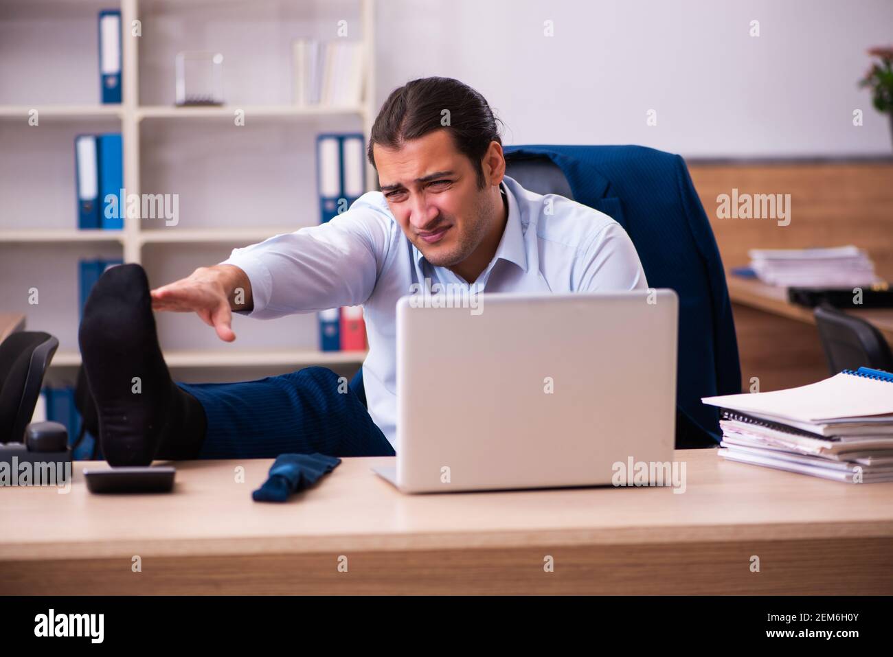 Young employee doing physical exercises at workplace Stock Photo - Alamy