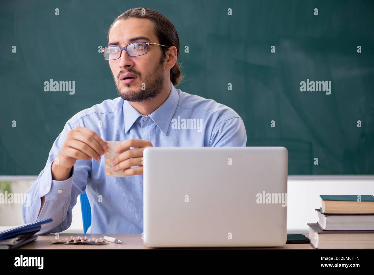 Young sick teacher in the classroom Stock Photo - Alamy
