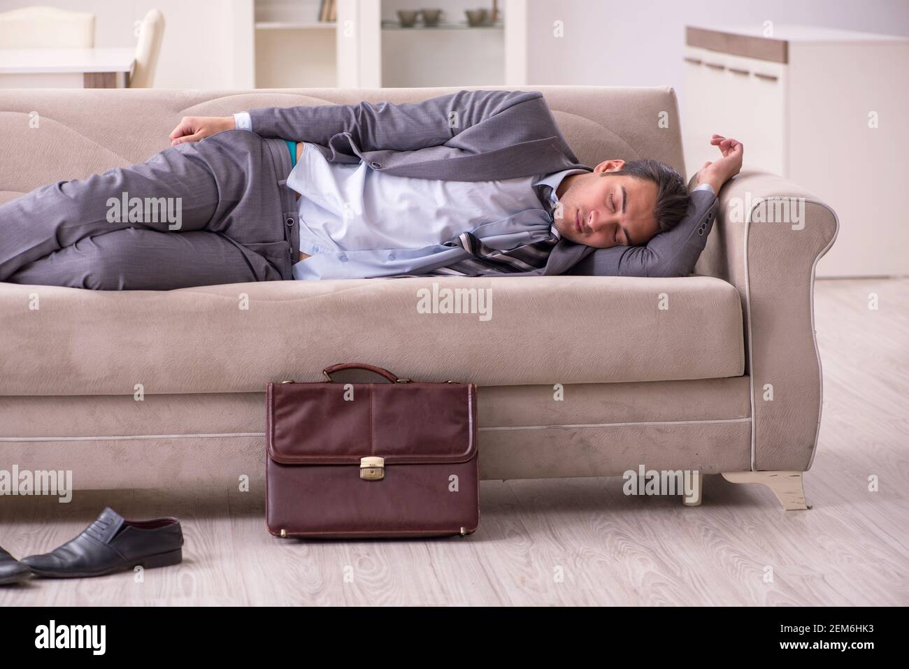 Tired businessman coming home after working day Stock Photo - Alamy