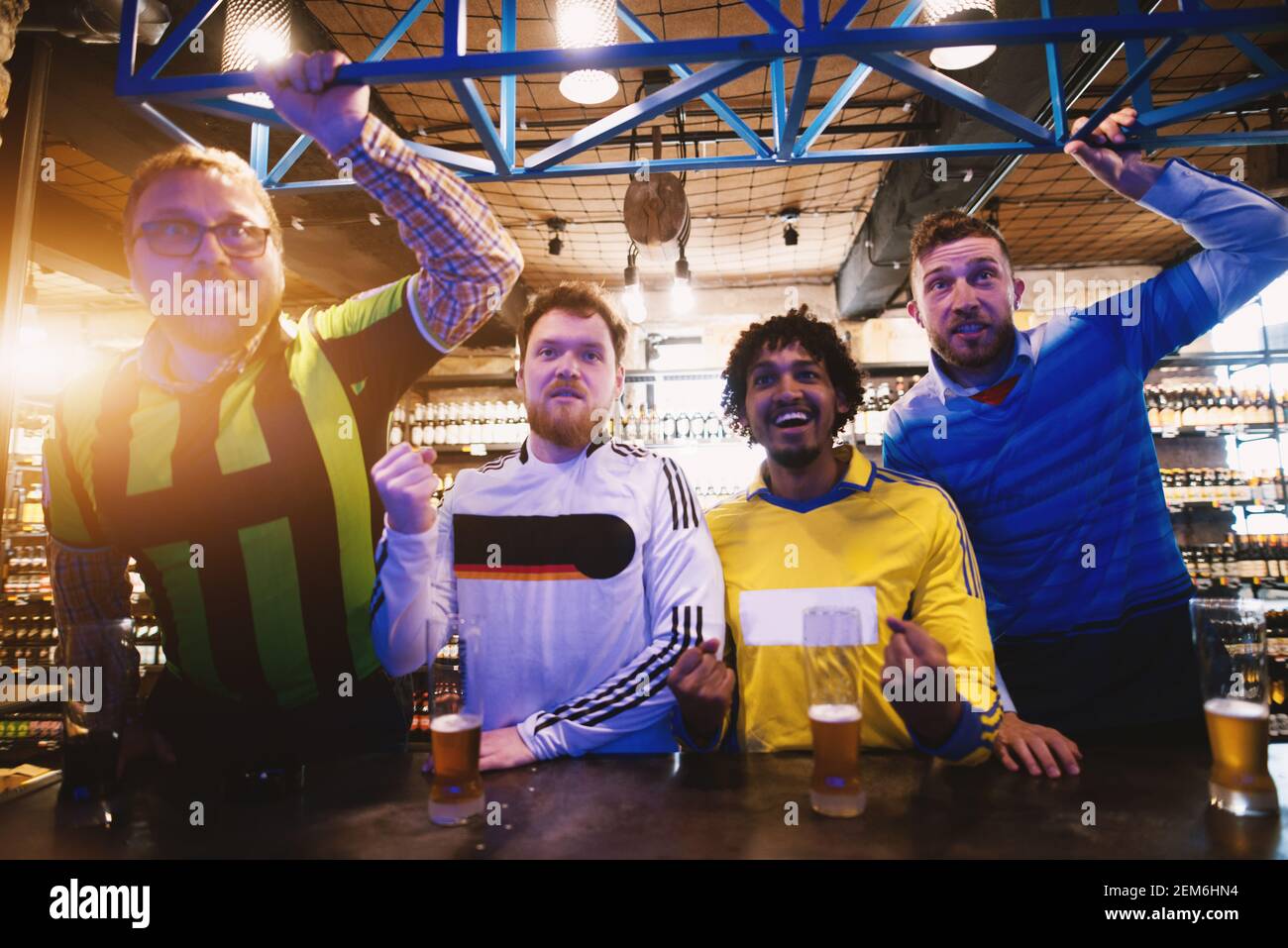 Passionate football fans are leaning over the counter in a tense ...
