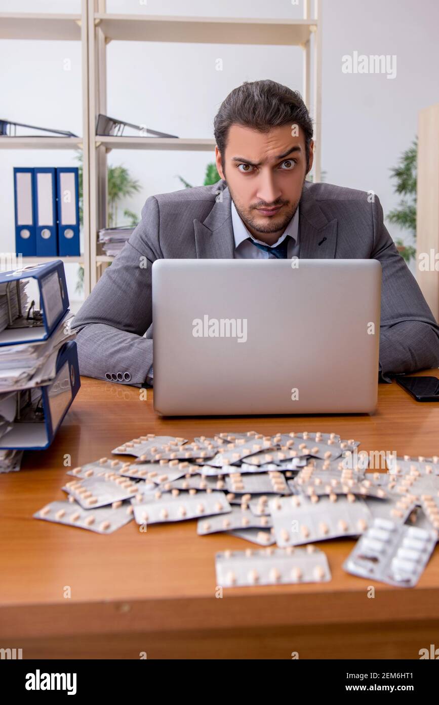 Male sick employee suffering at workplace Stock Photo - Alamy
