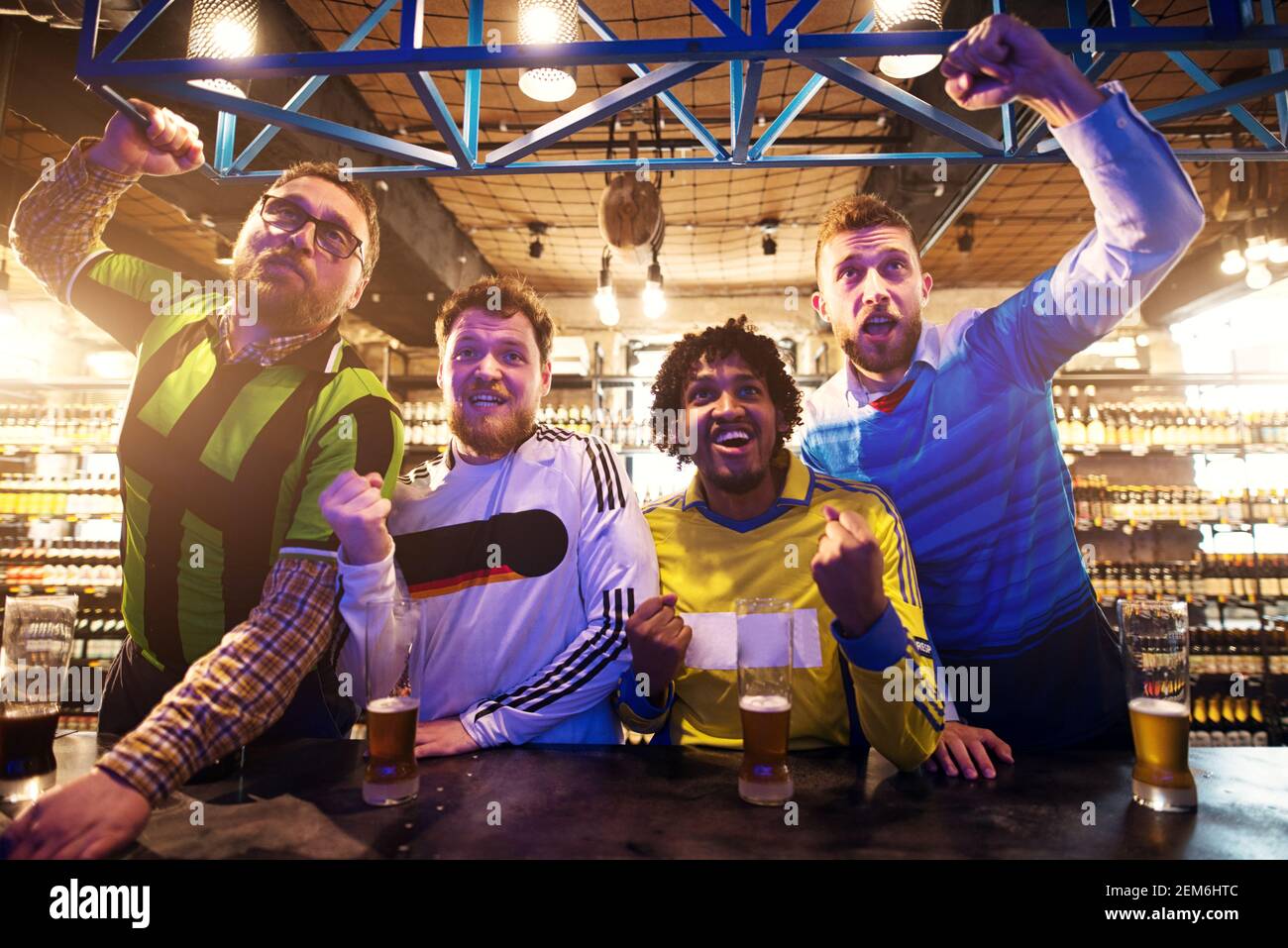Cheerful group of soccer fans are celebrating the goal their team has ...