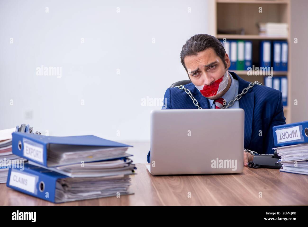 Chained employee unhappy with excessive work in the office Stock Photo ...