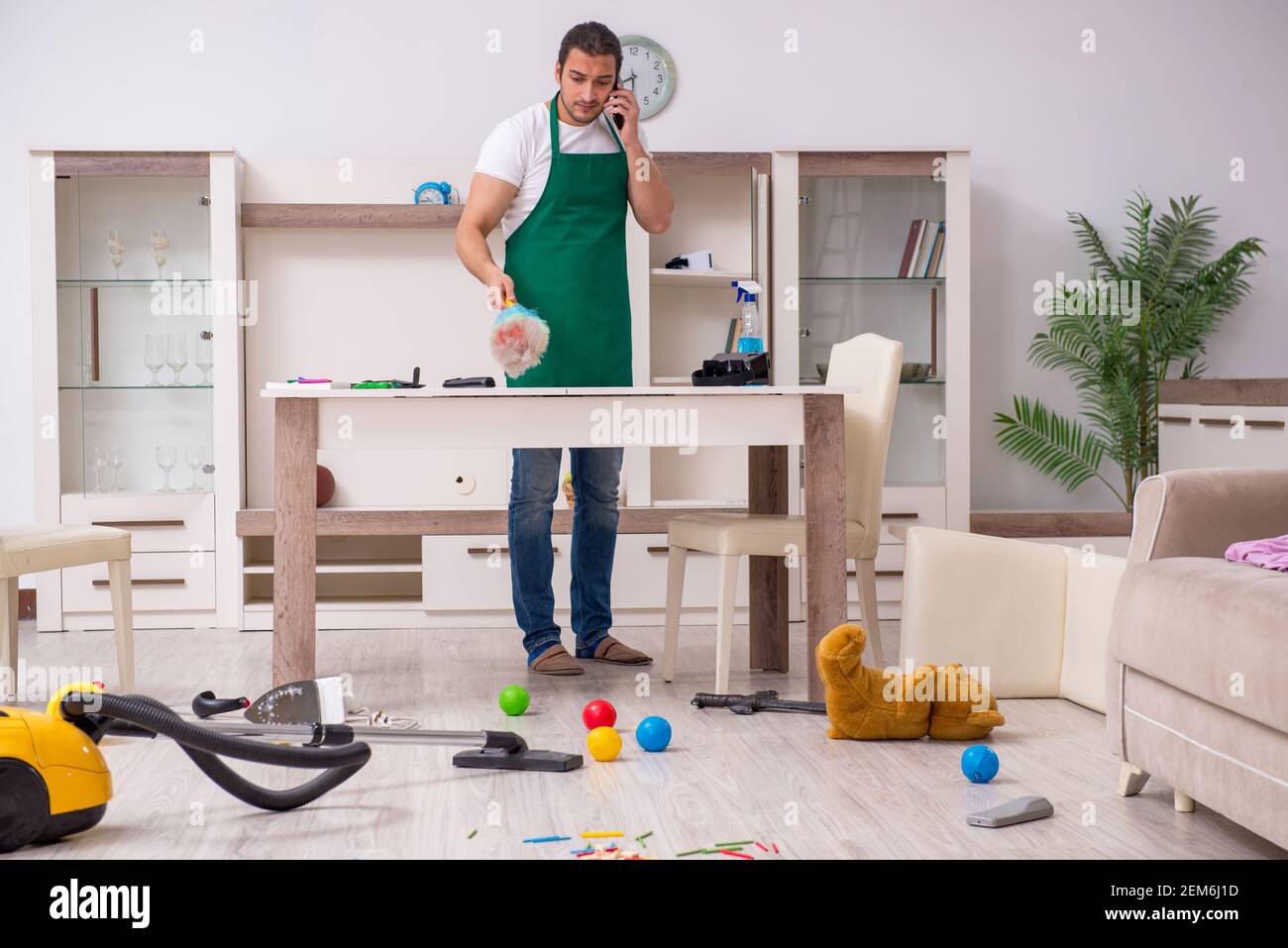 Young contractor cleaning the flat after kids' party Stock Photo - Alamy