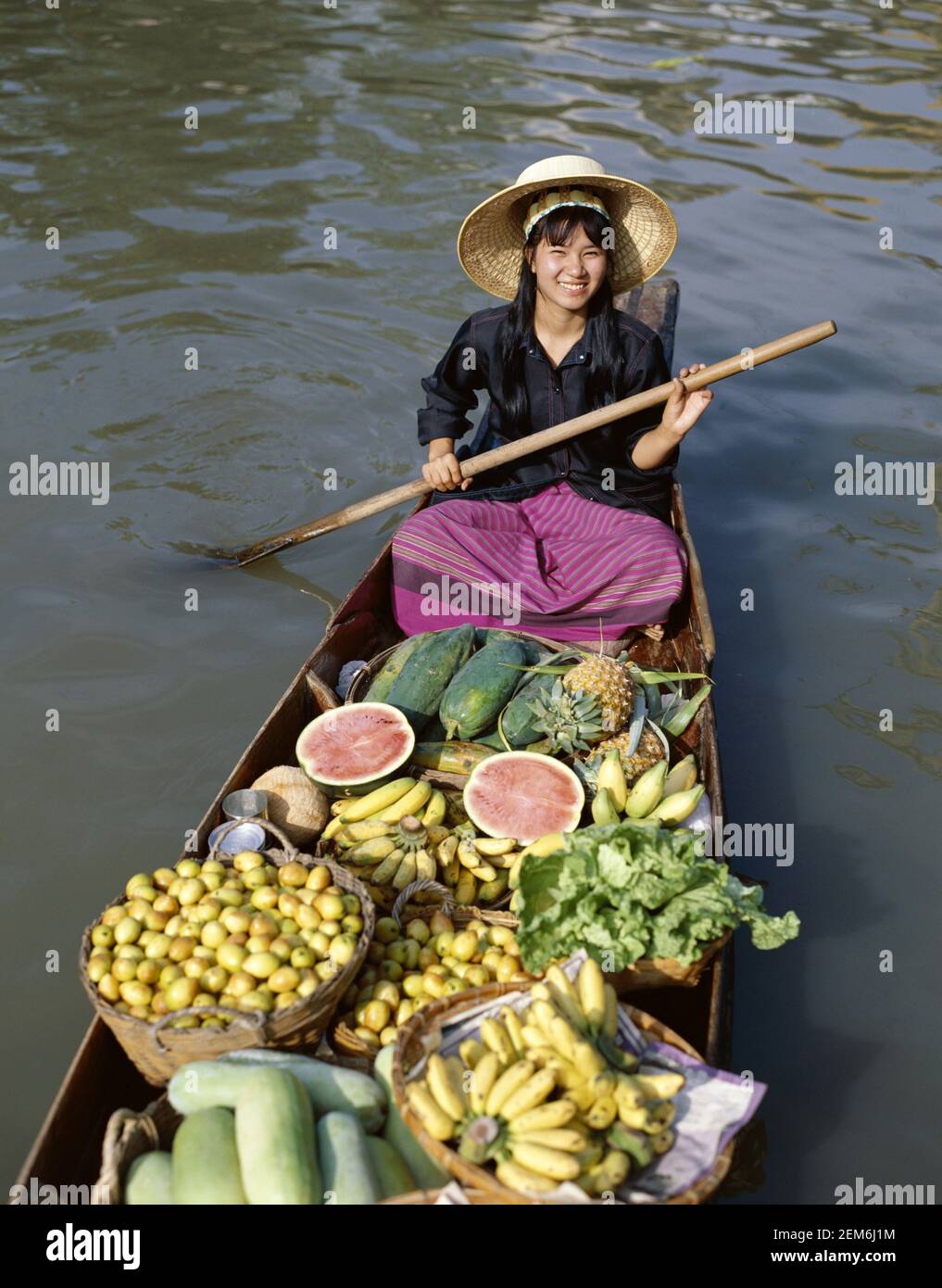 Asia, Thailand,Bangkok, Smiling Thai woman selling fruit and flowers at ...