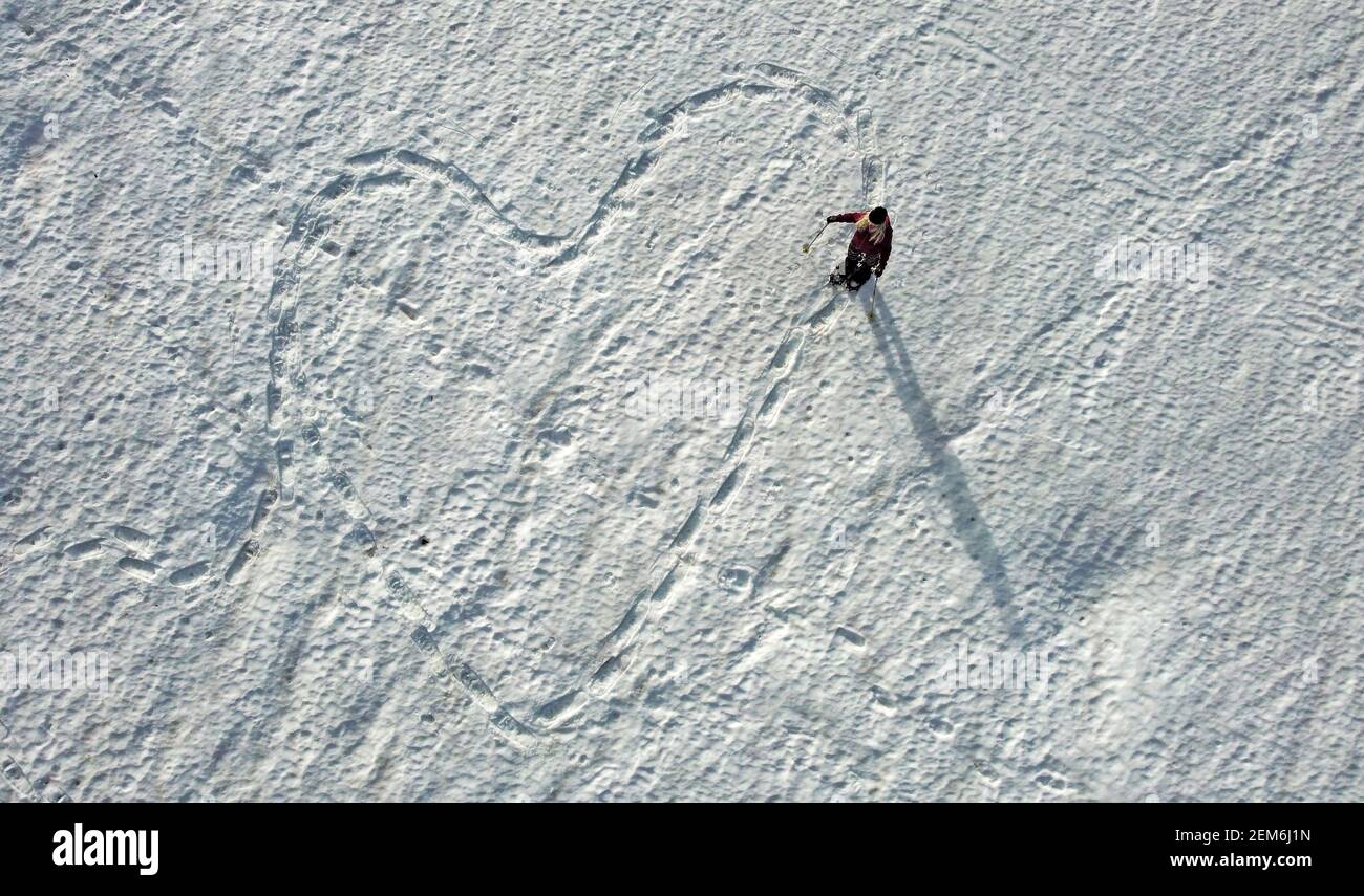 Aerial shot with a drone of a snow school runner making a trail in the ...