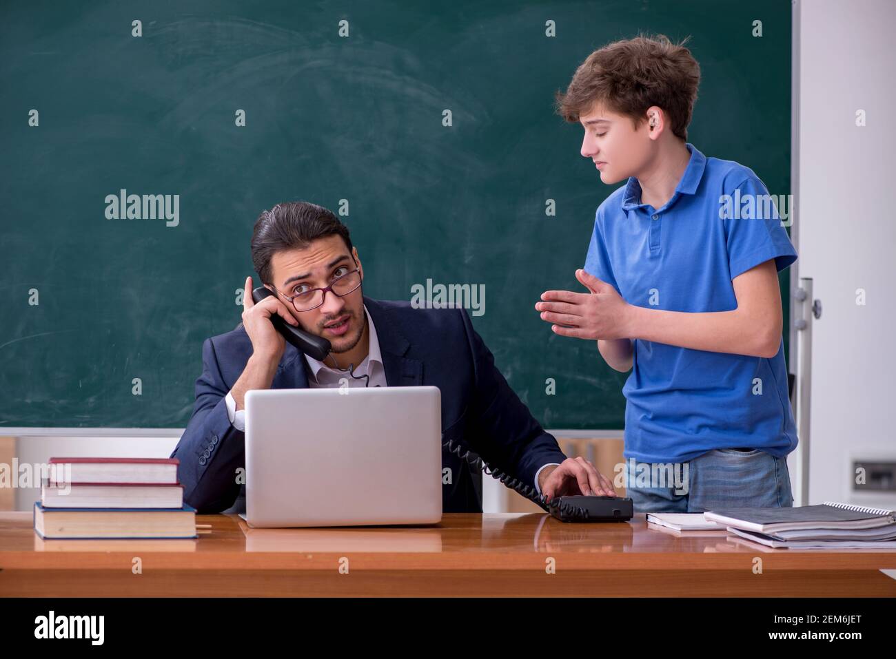 Male teacher and schoolboy in the classroom Stock Photo - Alamy
