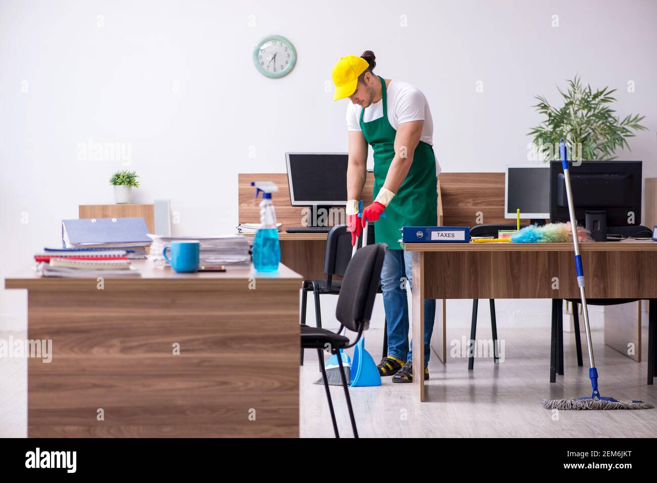 Young contractor cleaning the office Stock Photo - Alamy