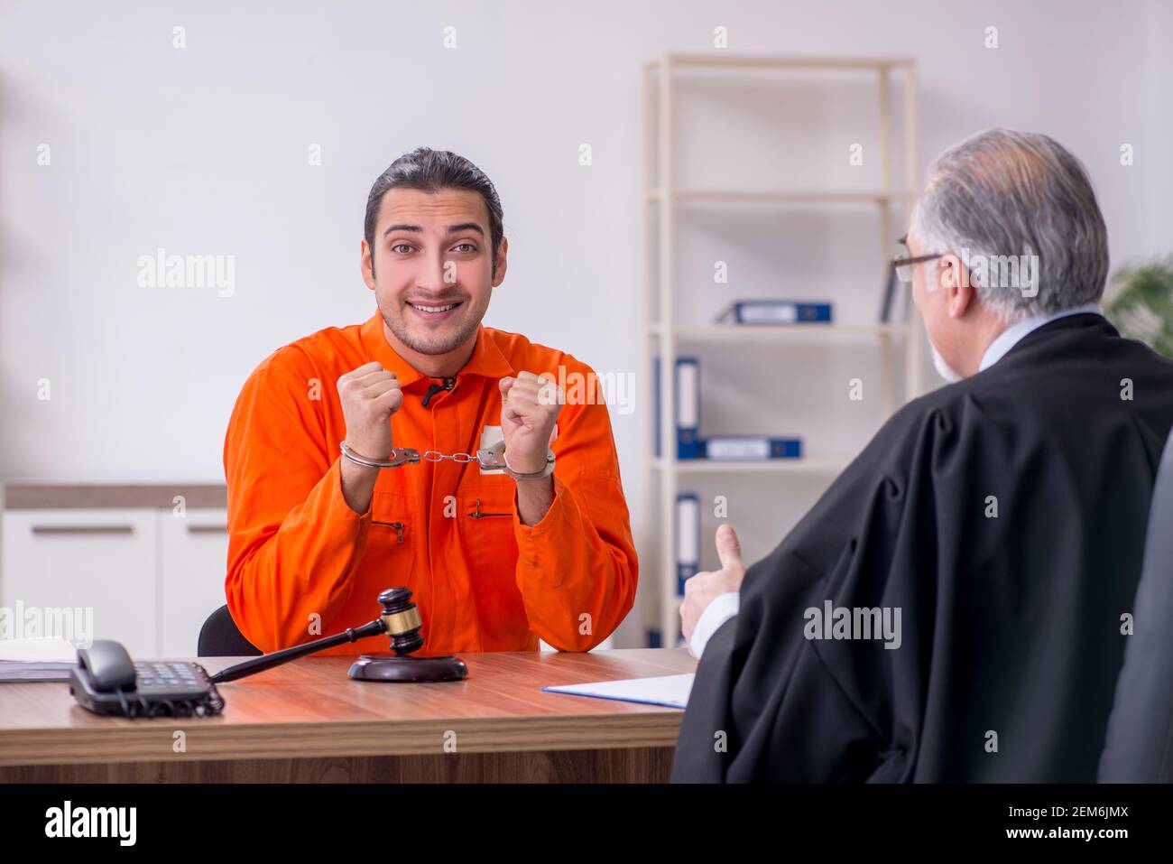 Old judge meeting with young captive in courthouse Stock Photo - Alamy