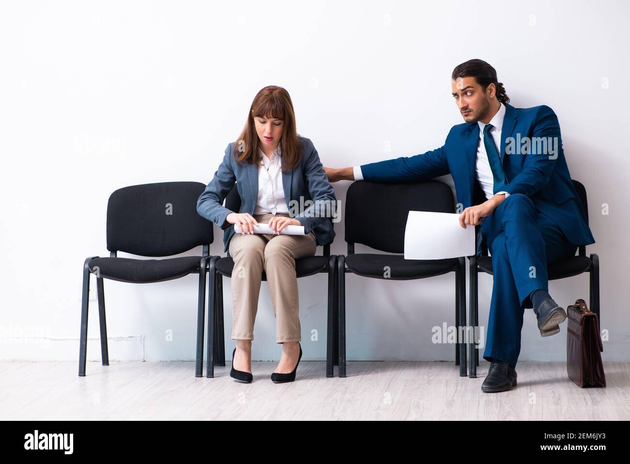 Businessman and businesswoman waiting for an interview at hall Stock ...