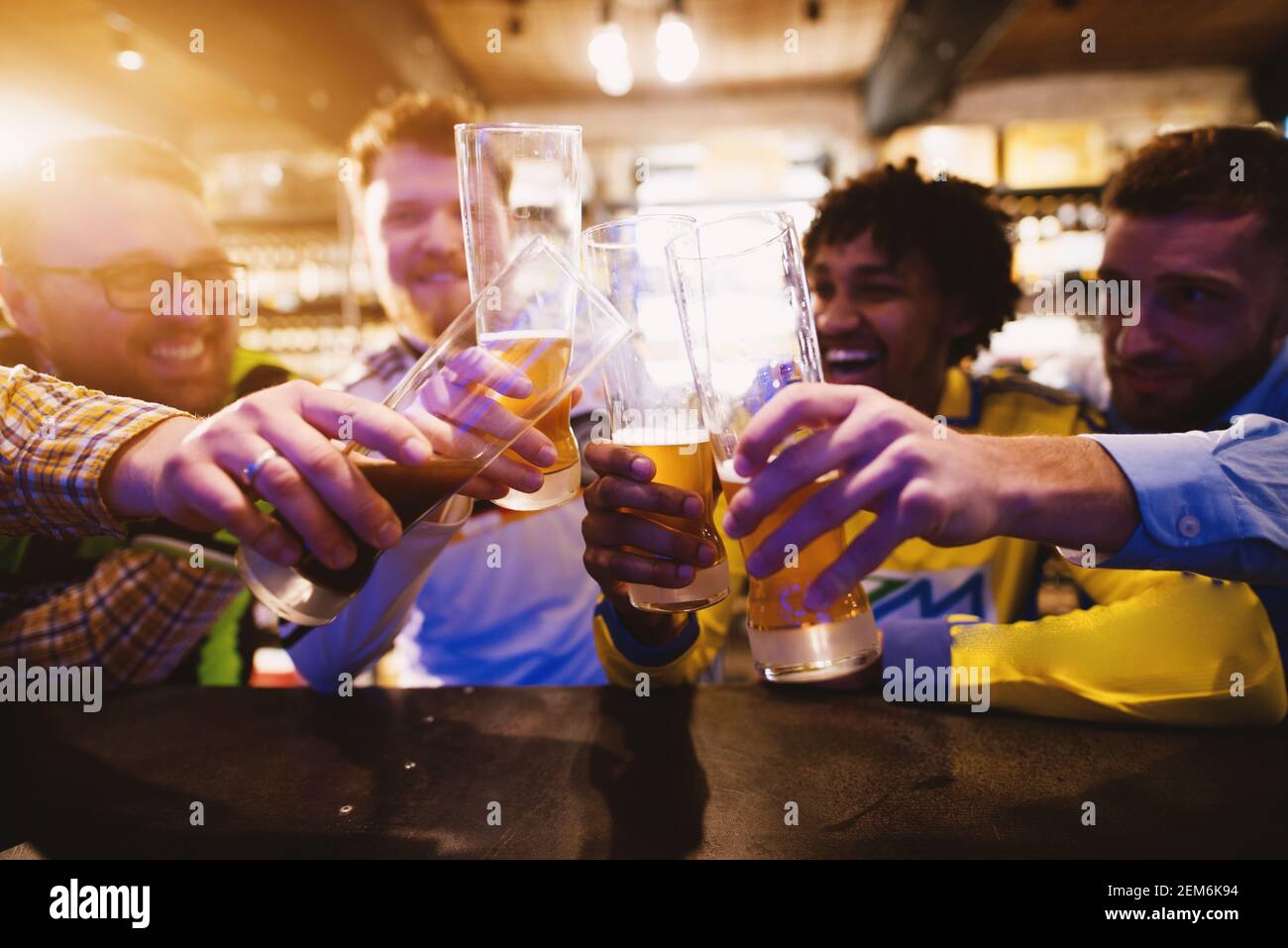 Soccer fans are celebrating their teams victory by saluting with a beer ...