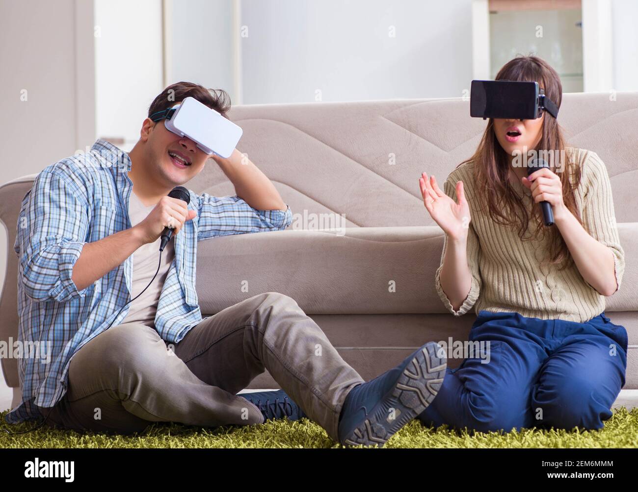 The pair singing karaoke with virtual reality glasses Stock Photo - Alamy