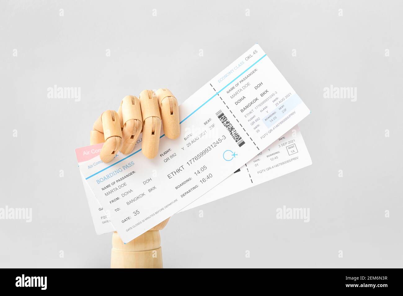 Wooden hand with tickets on light background Stock Photo - Alamy