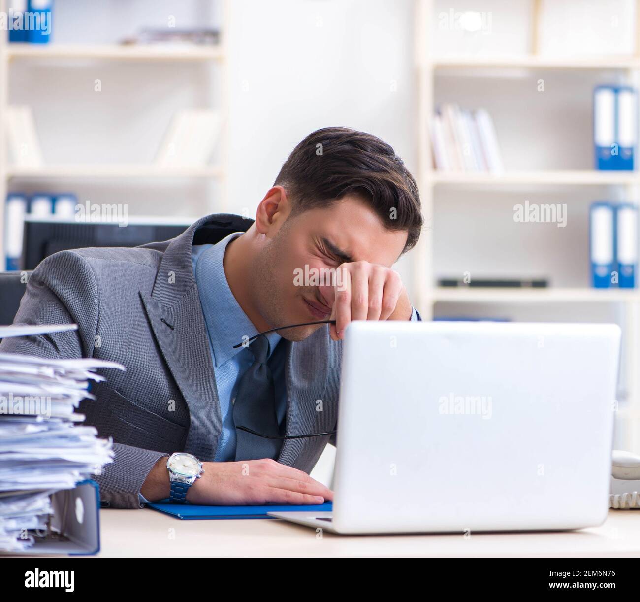 The overloaded with work employee under paperwork burden Stock Photo ...