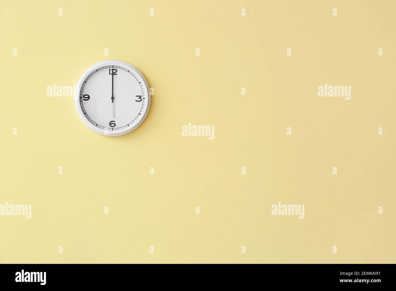 Stylish clock hanging on color wall Stock Photo - Alamy