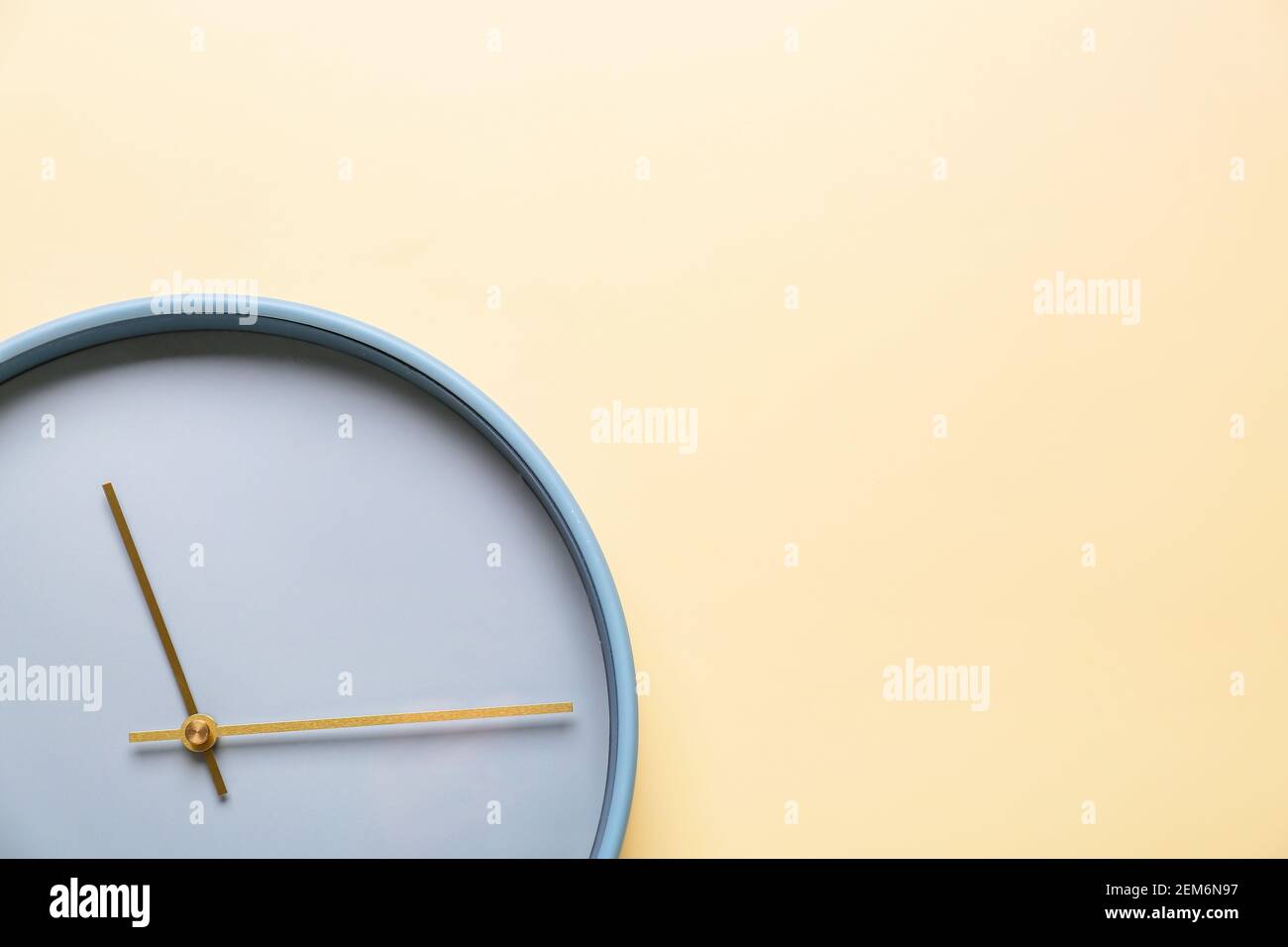 Stylish clock hanging on color wall Stock Photo - Alamy