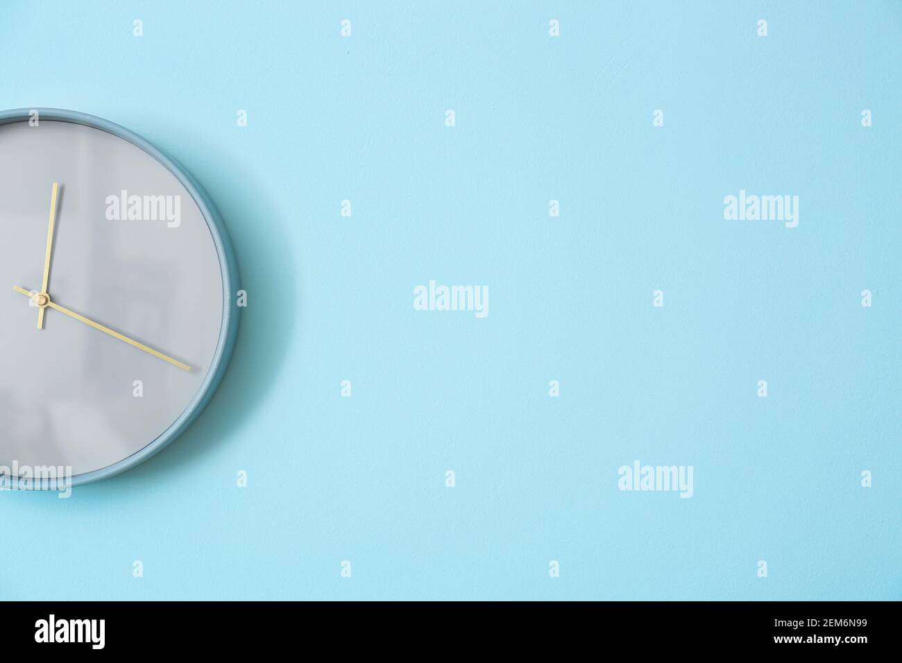Stylish clock hanging on color wall Stock Photo - Alamy