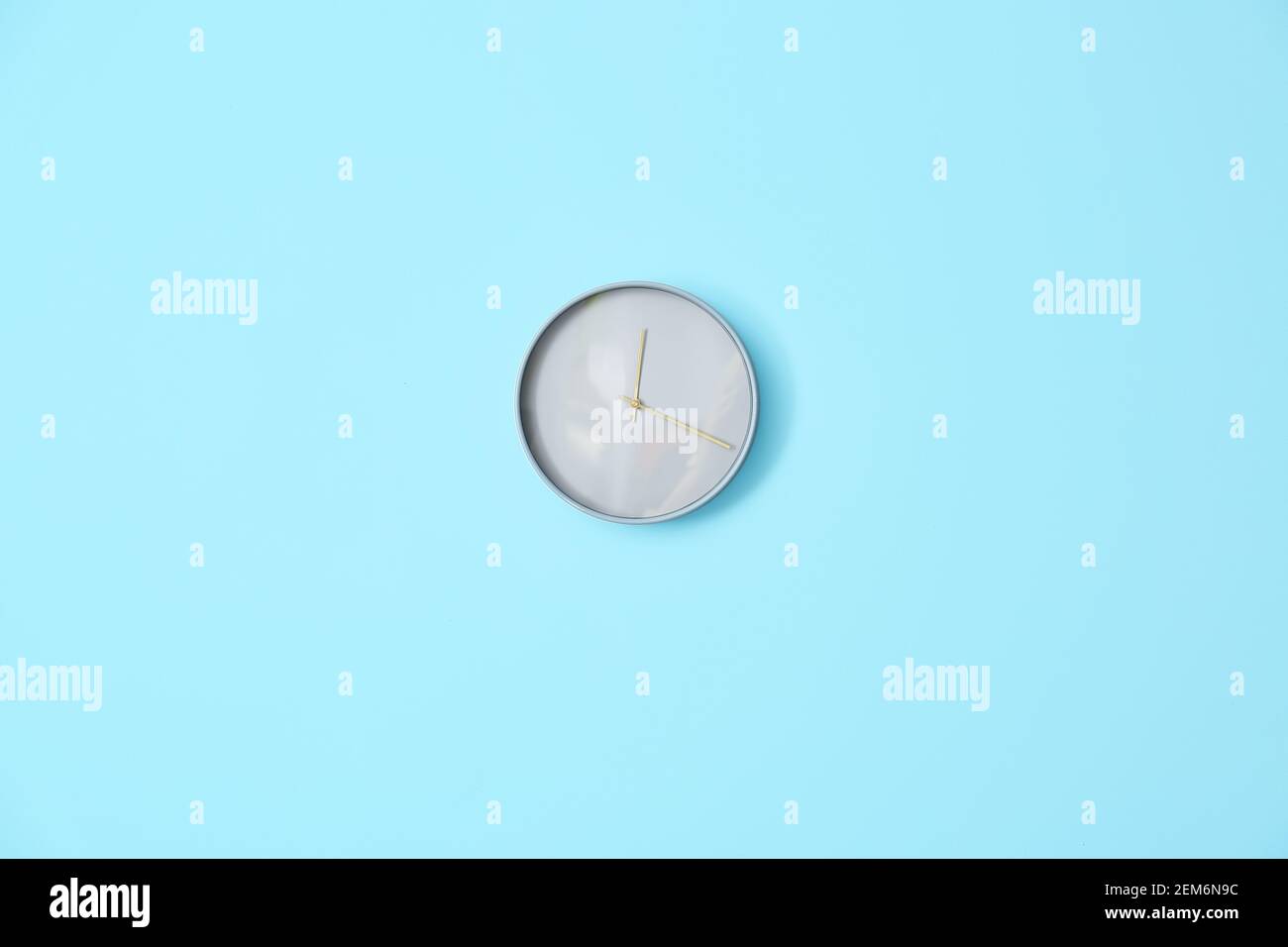 Stylish clock hanging on color wall Stock Photo - Alamy