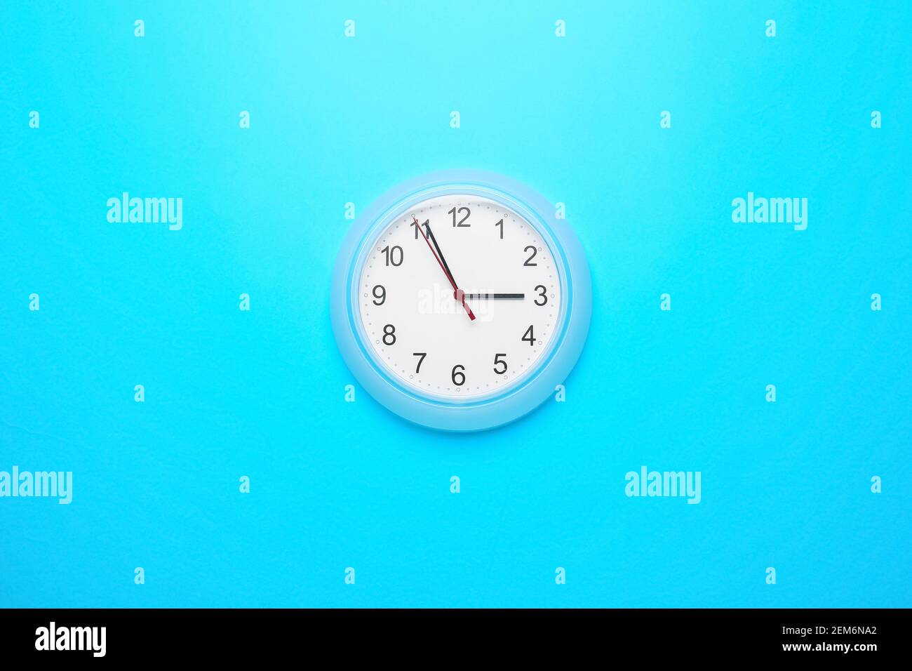 Stylish clock hanging on color wall Stock Photo - Alamy