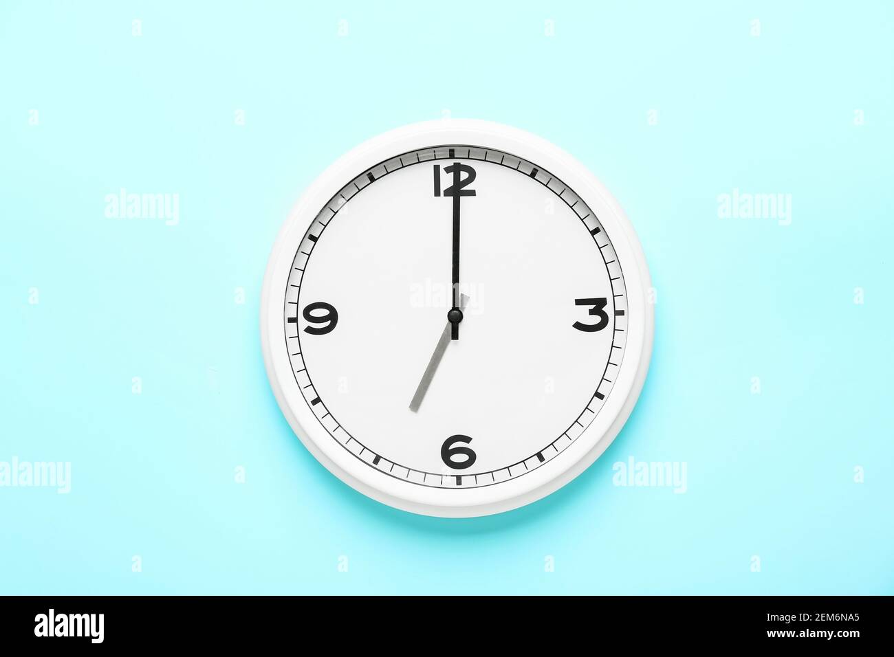 Stylish clock hanging on color wall Stock Photo - Alamy
